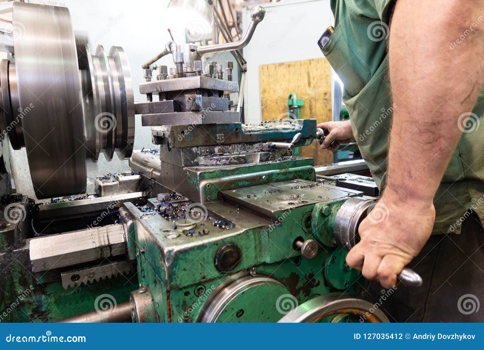 Worker, a Man Processes Metal Products on a Machine. Turning Work in ...