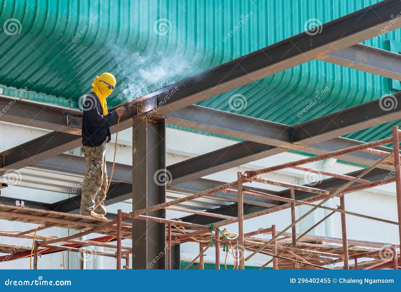 Worker Man Welder Stand on Scaffolding Support Welds an Iron Beam Stock ...