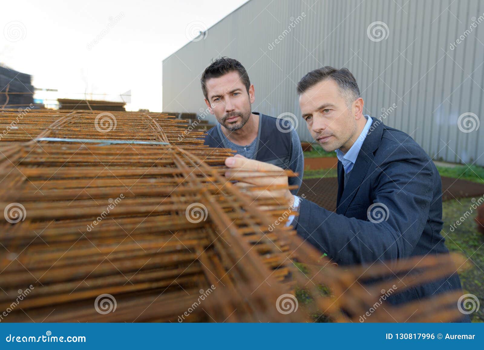 Worker and Manager Inspecting Concrete Reinforcement Pieces at Yard ...
