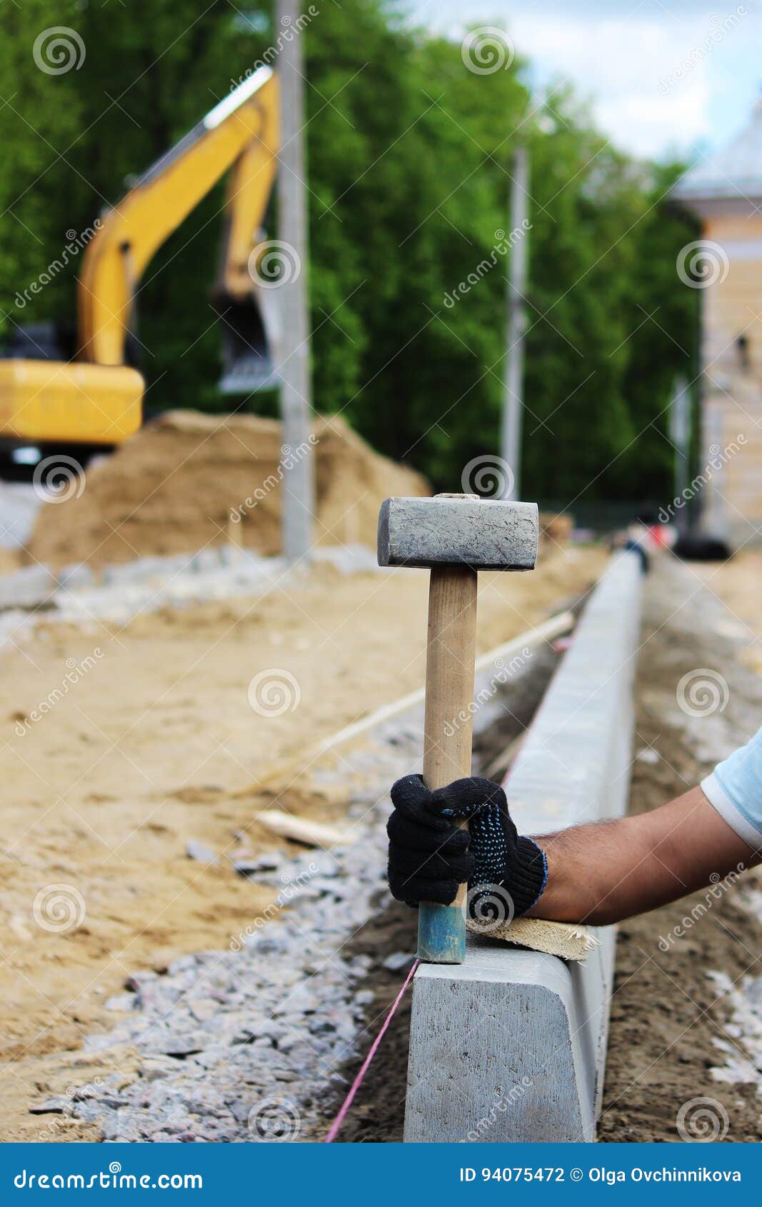 The Worker Mason Shows a Hammer with Which the Pavement Curb is Laid ...