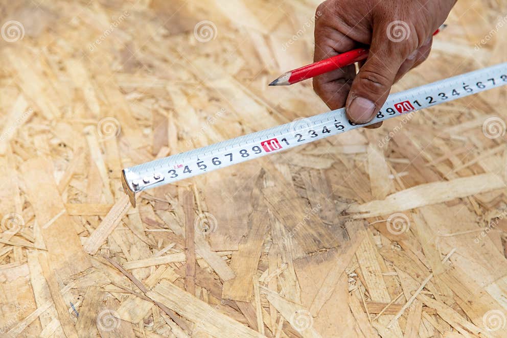 Worker Measures the Board at a Construction Site Stock Photo - Image of ...