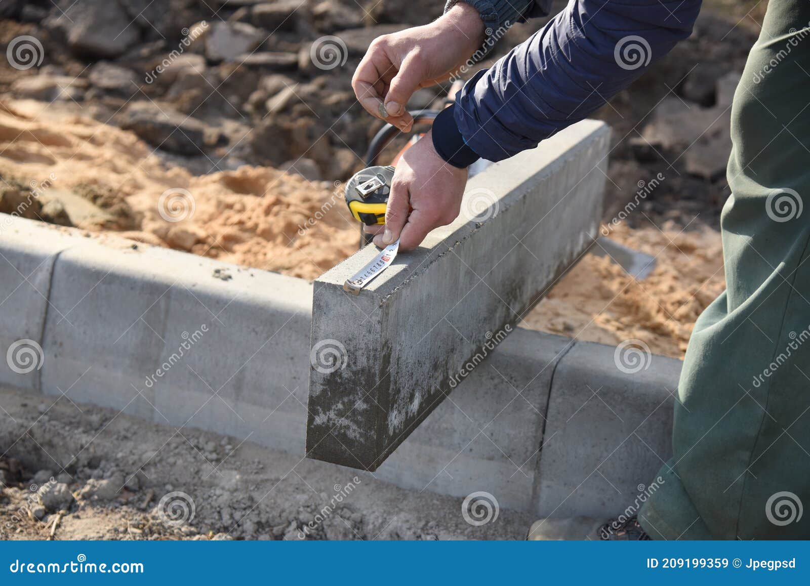 A Worker Measures a Concrete Block of Pavement with a Ruler ,the ...