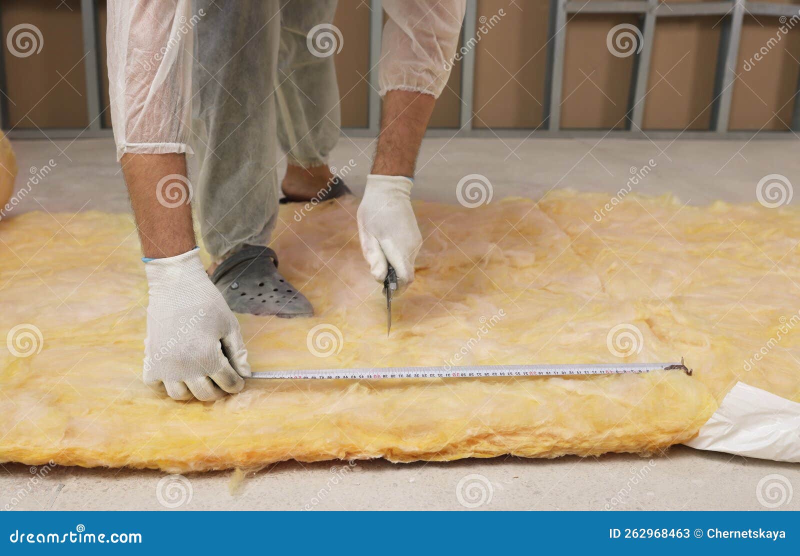 Worker Measuring and Cutting Insulation Material Indoors, Closeup ...