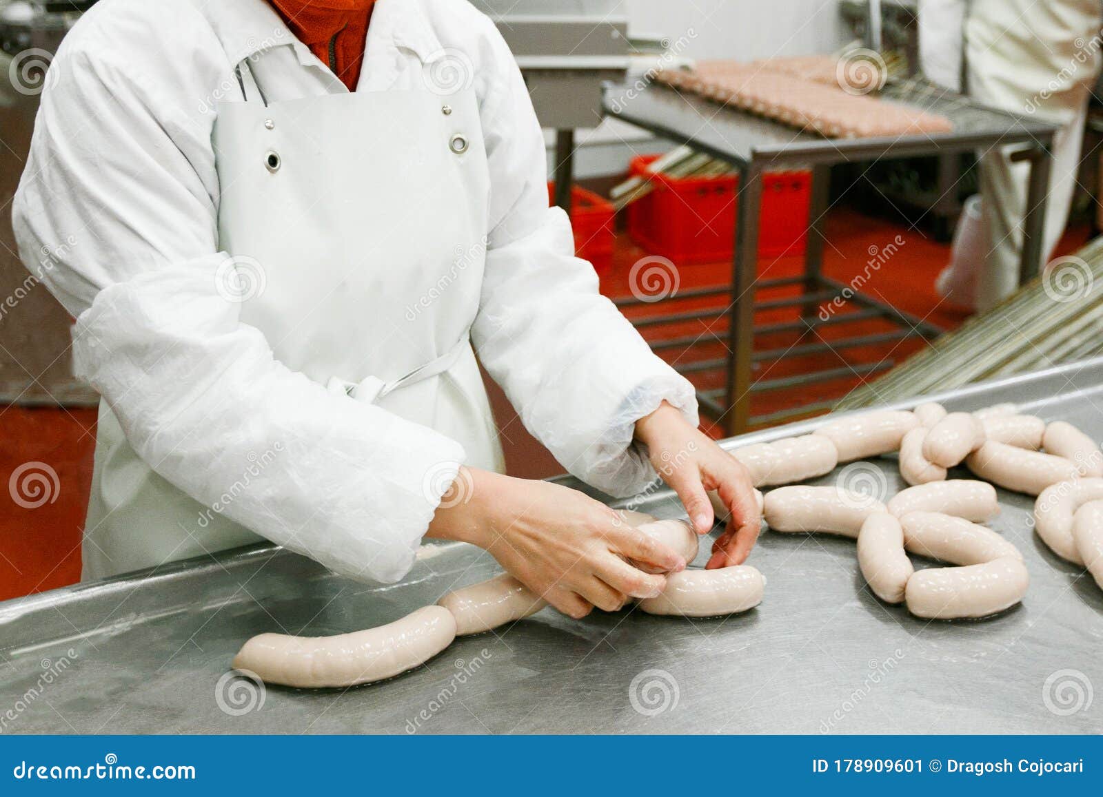 A Worker at the Meat Processing Factory, Prepares Sausages at the Work ...