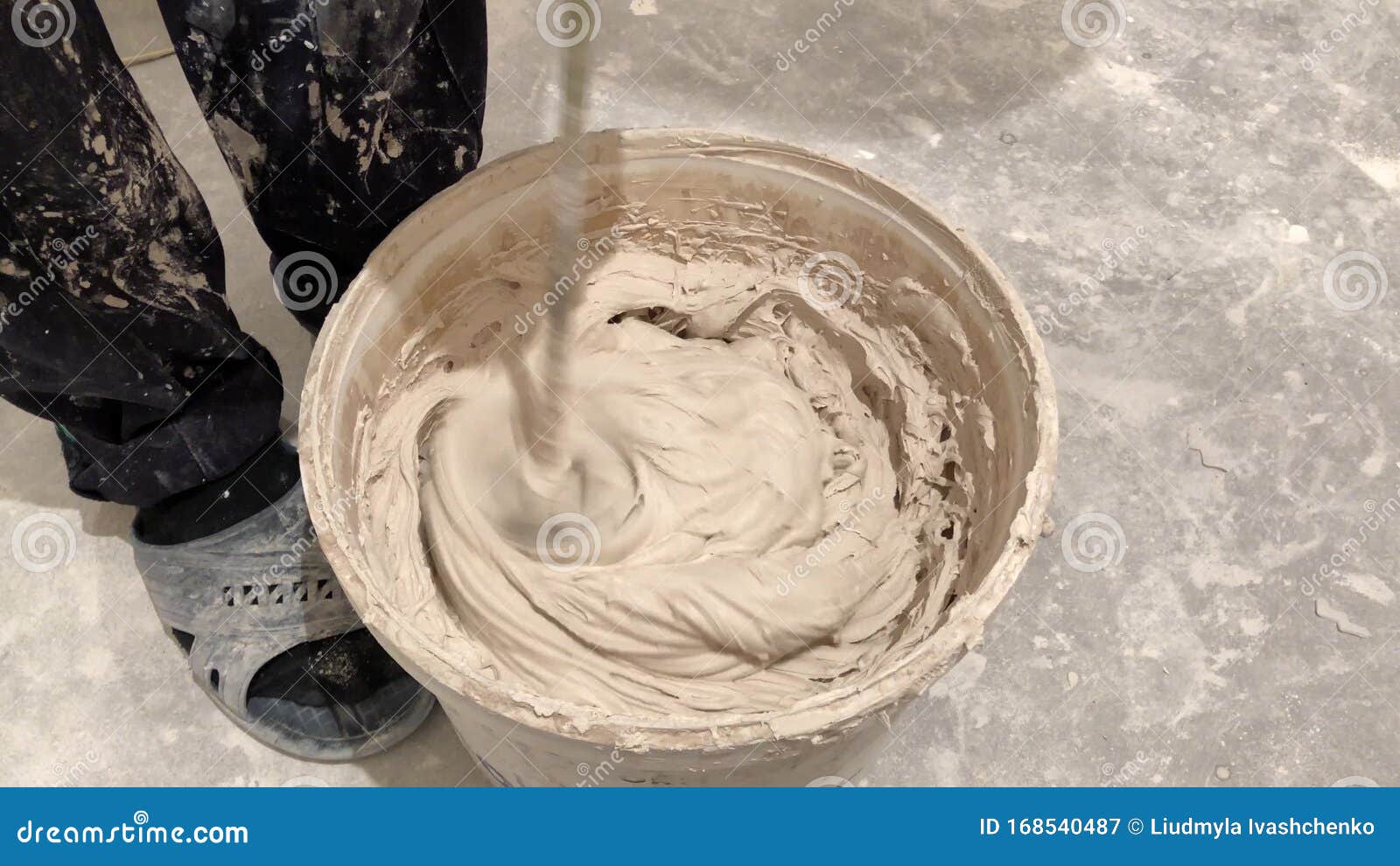 Worker Mixing Plaster Solution in a Bucket, Using an Electric Drill ...