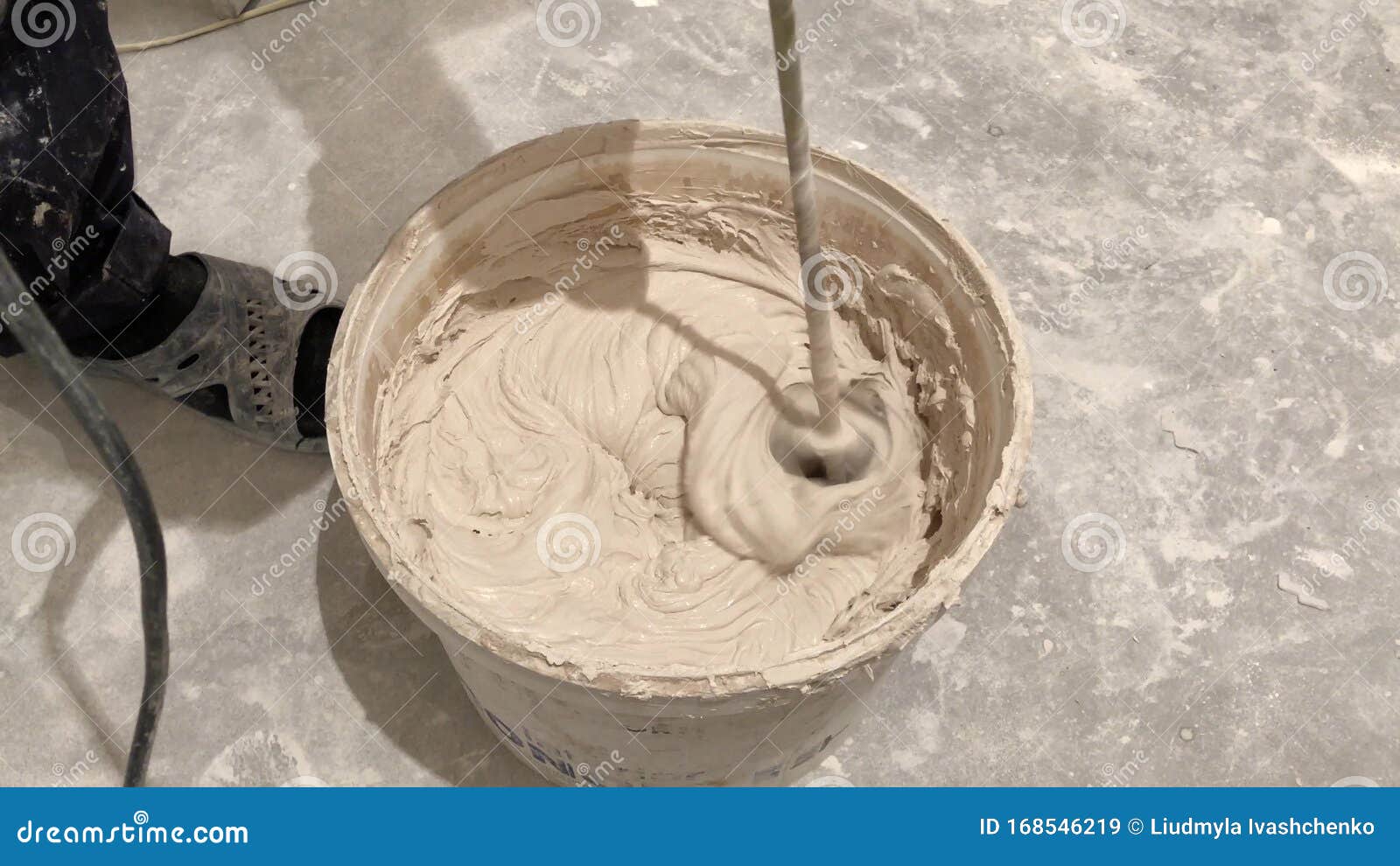 Worker Mixing Plaster Solution in a Bucket, Using an Electric Drill ...
