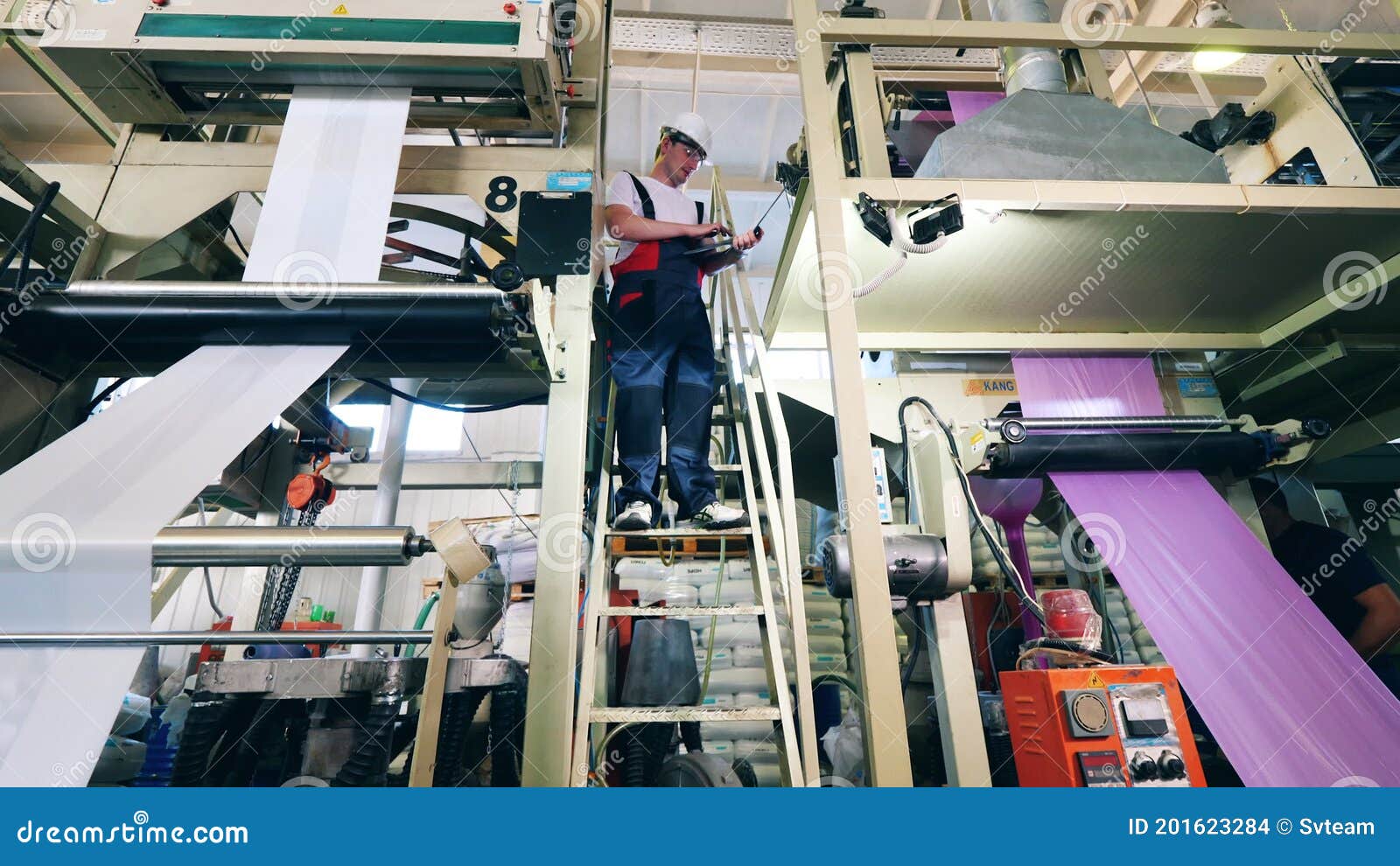 A Worker is Observing Manufacturing Process of Polyethylene Foil Stock ...