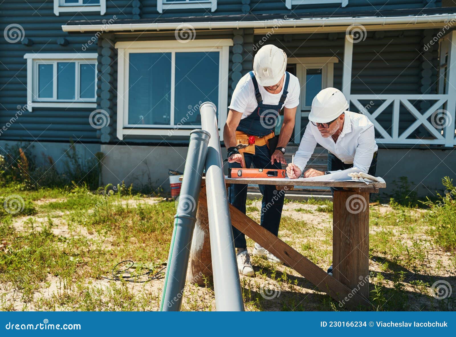 Housebuilder With Drawings In Arms Leaning On Porch Railings Royalty ...