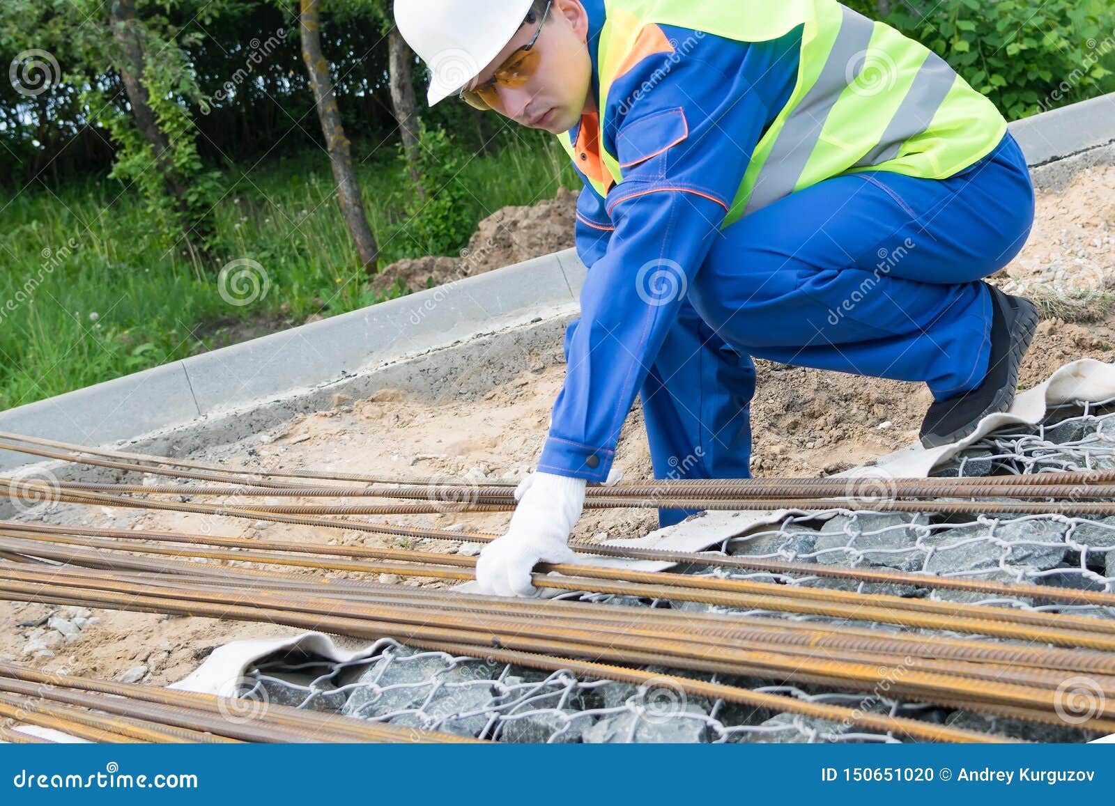 Worker in Overalls Takes Iron Rods for Construction, Close-up Stock ...