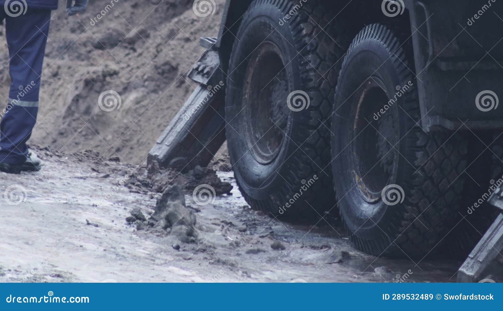 A Worker in Overalls Watches the Process of Digging a Hole with an ...