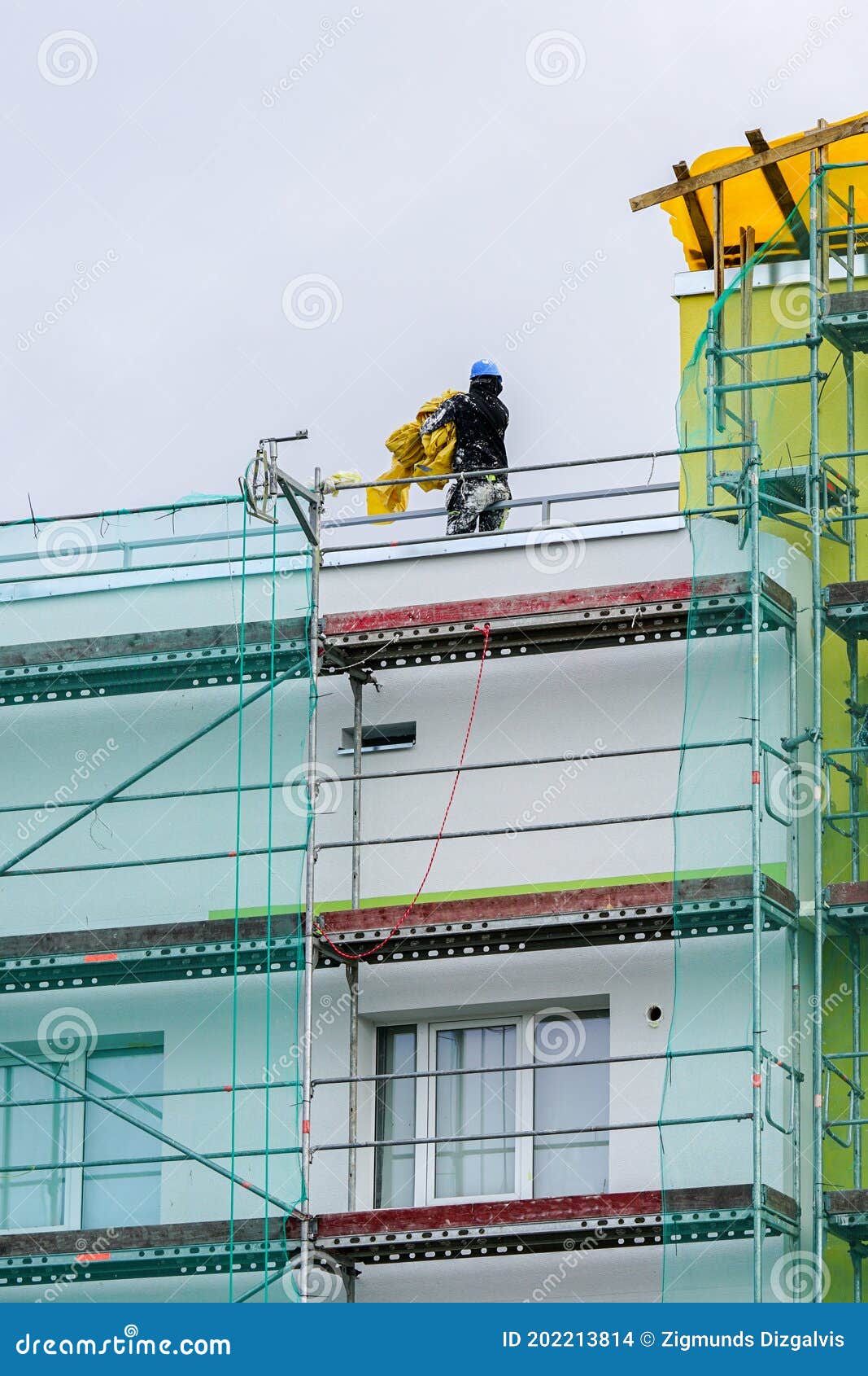 A Worker Performs Dangerous Activities on the Roof of a High House ...