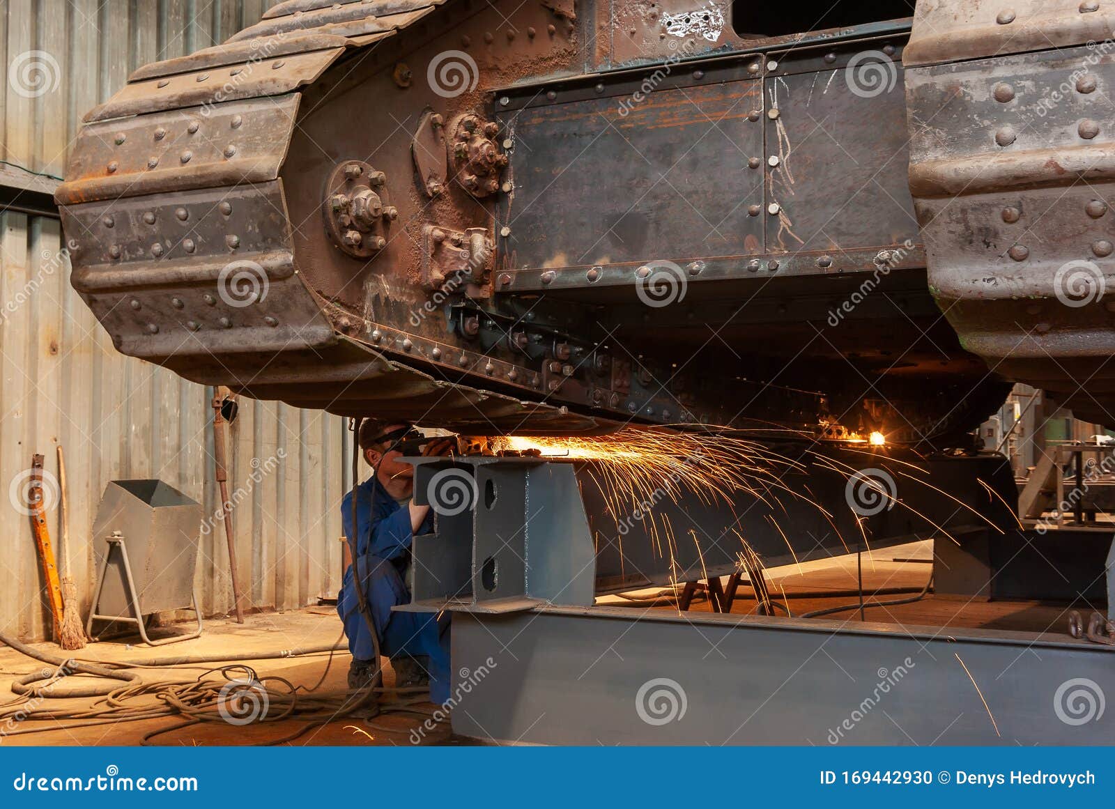 A Worker Performs Grinding Work on a Old Armored Tank in a Factory ...