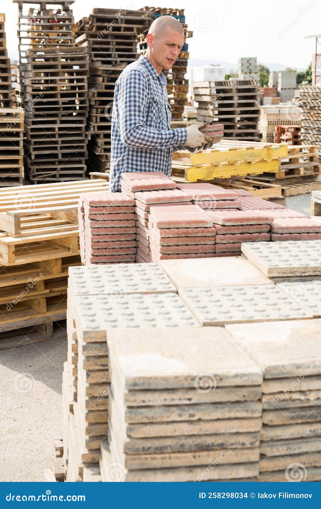 Worker Places Paving Slabs on a Pallet in Building Materials Warehouse ...