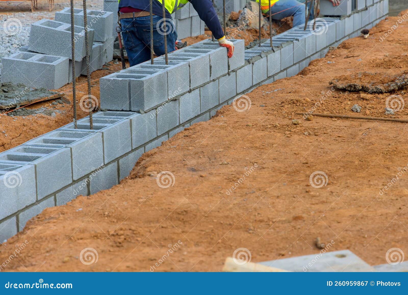 Worker Placing Cement Blocks Along Another Row of Bricks in a ...