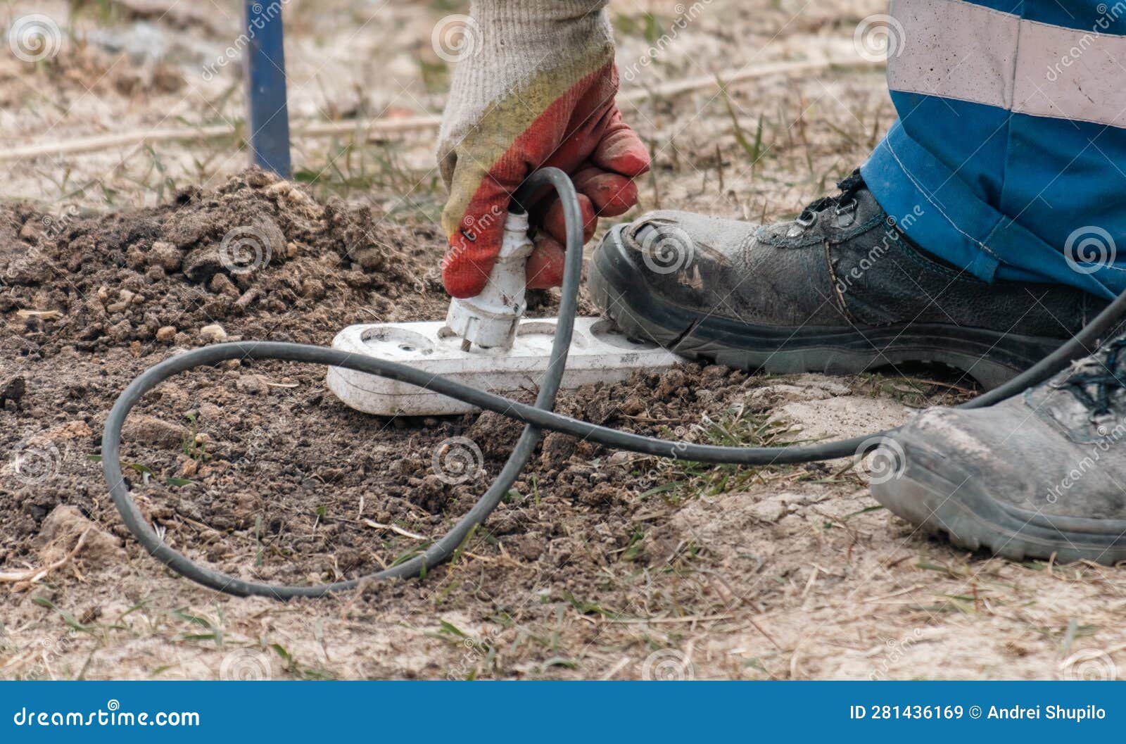 A Worker Plugs the Plug into an Extension Socket at a Construction Site ...