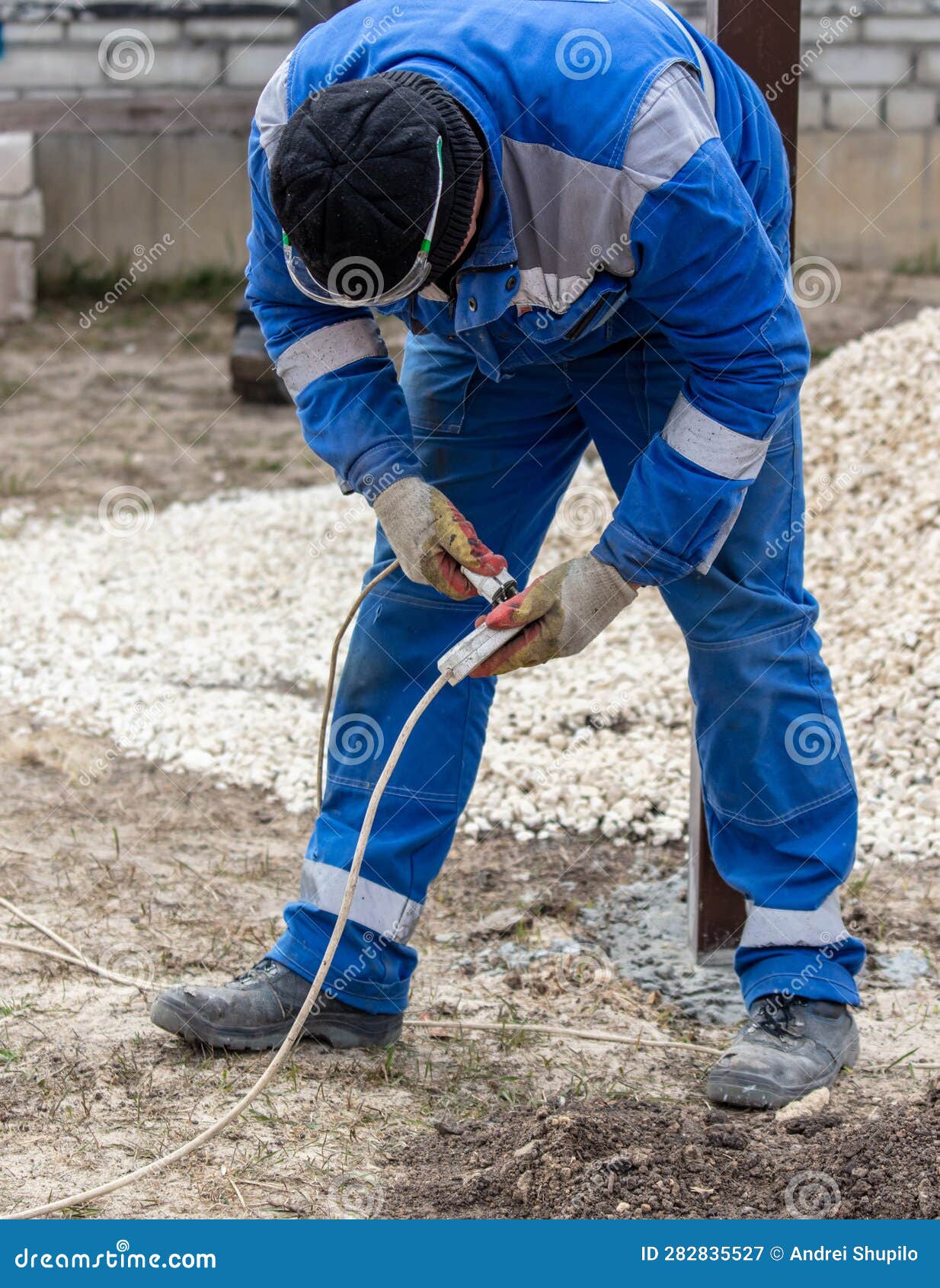 A Worker Plugs the Plug into an Extension Socket at a Construction Site ...