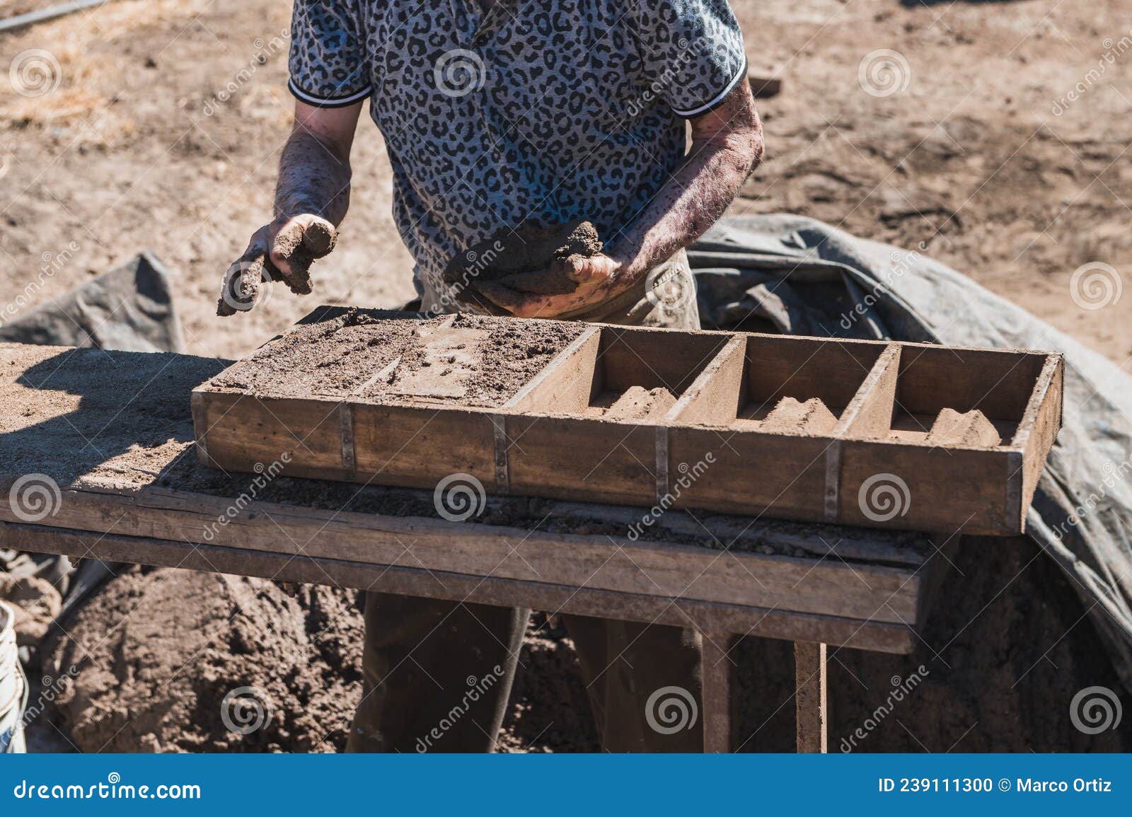 Worker Pours the Mixture of Mud, Sand and Sawdust Over Molds for Making ...
