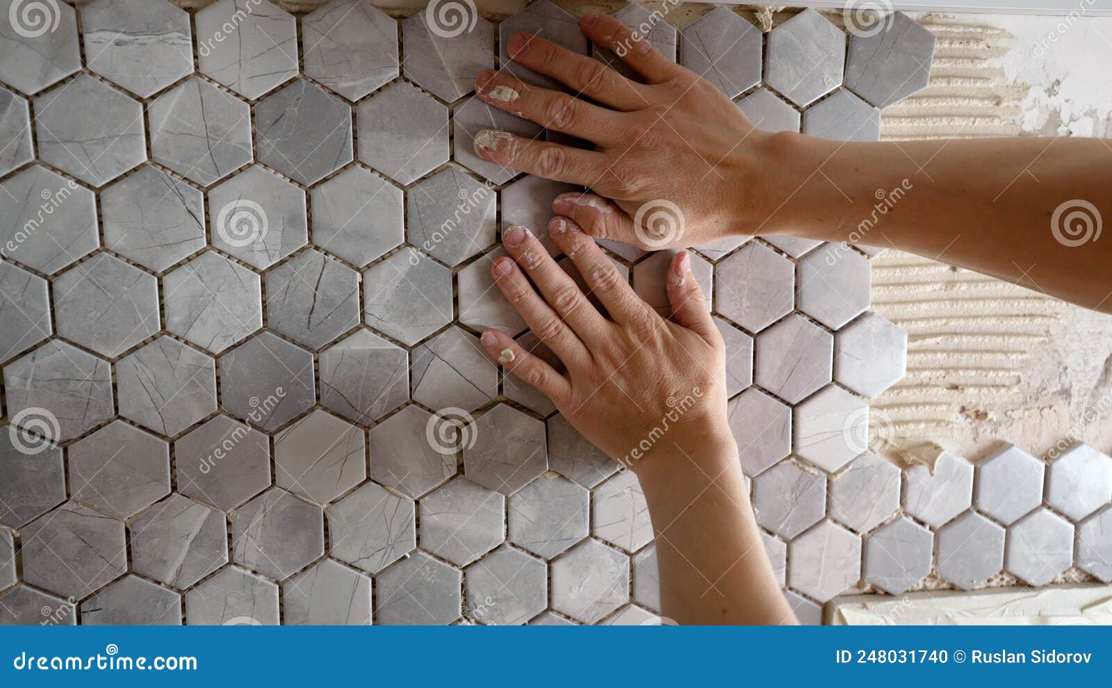 The Worker Presses the Tile with His Hands while Gluing the Tile. the ...