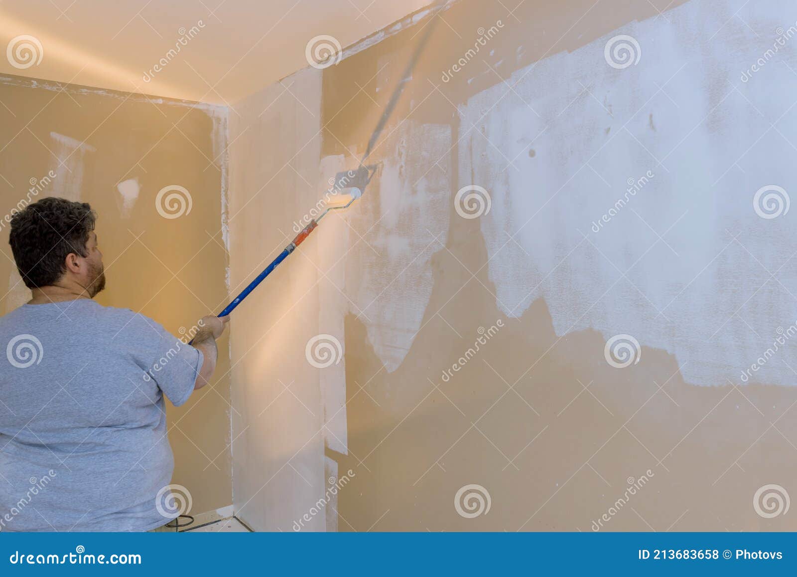 Worker Priming Walls In New Building. Roller Brush With Prime Covering ...
