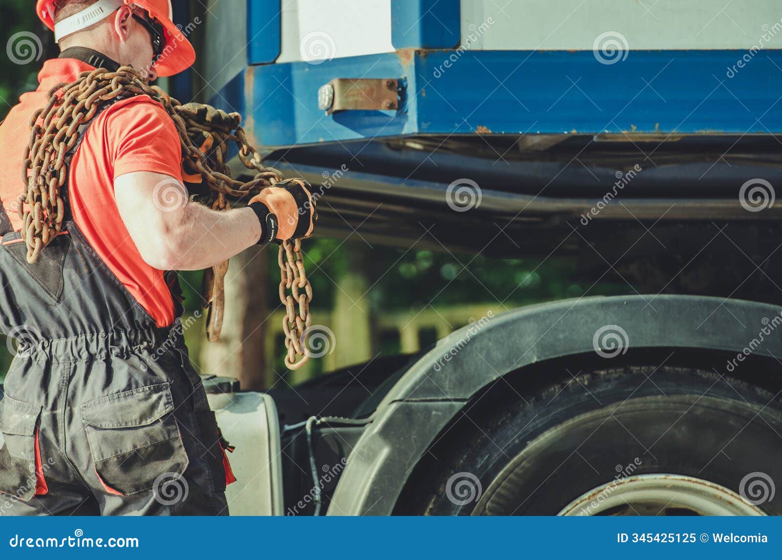 A Worker Secures A Large Cargo Container With Heavy Chains In An ...