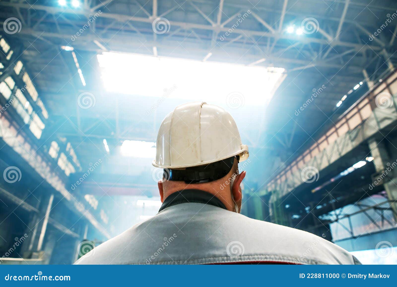 Worker in a Protective Helmet Against the Background of an Industrial ...