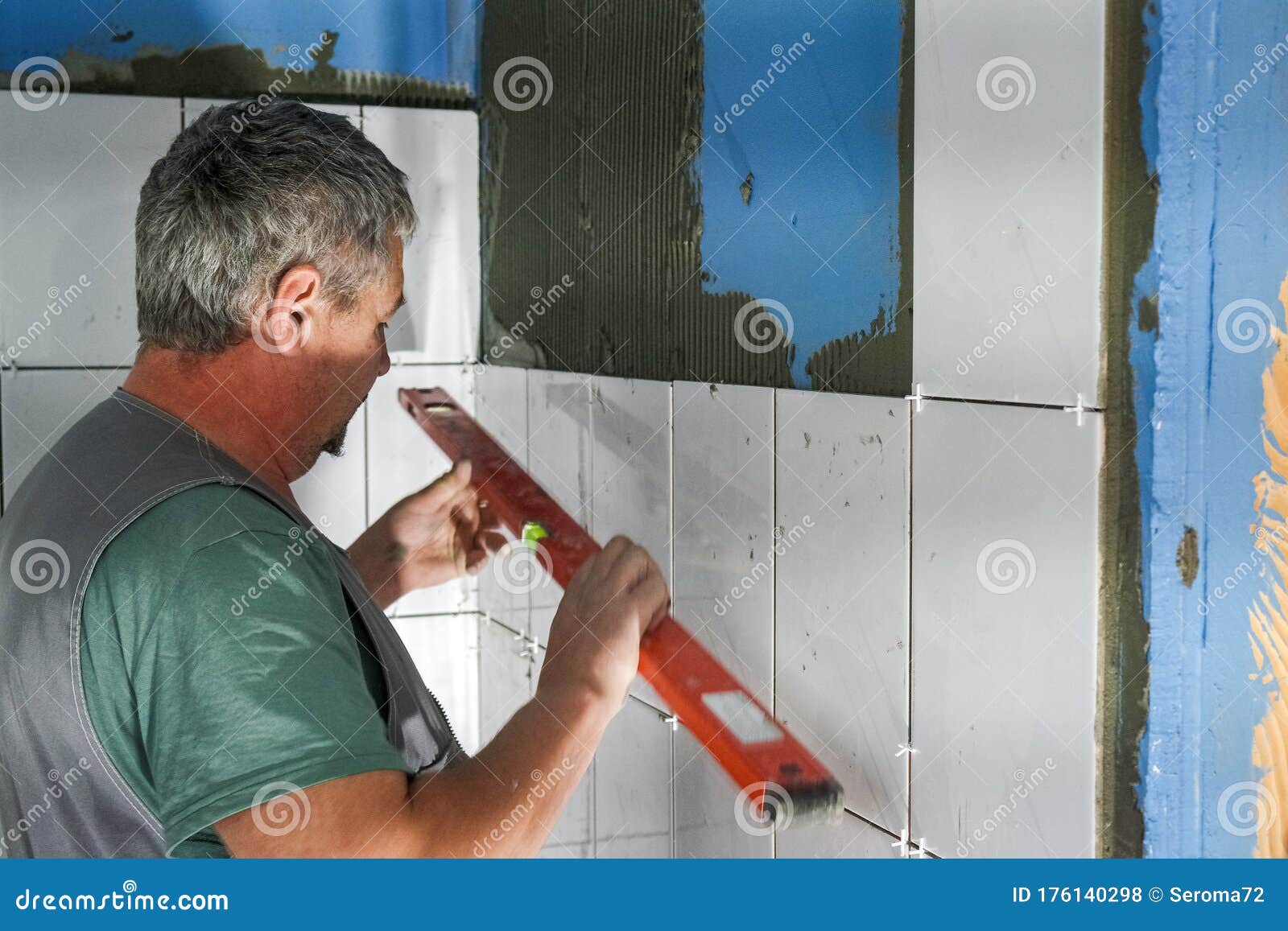 The Worker Puts Ceramic Tiles on the Construction Site Stock Photo ...