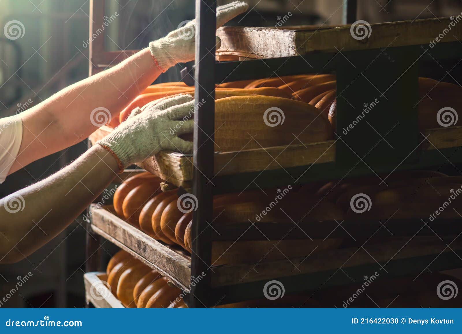 Worker Puts Fresh Bread on Rack. Baker Working at Bakery Stock Photo ...