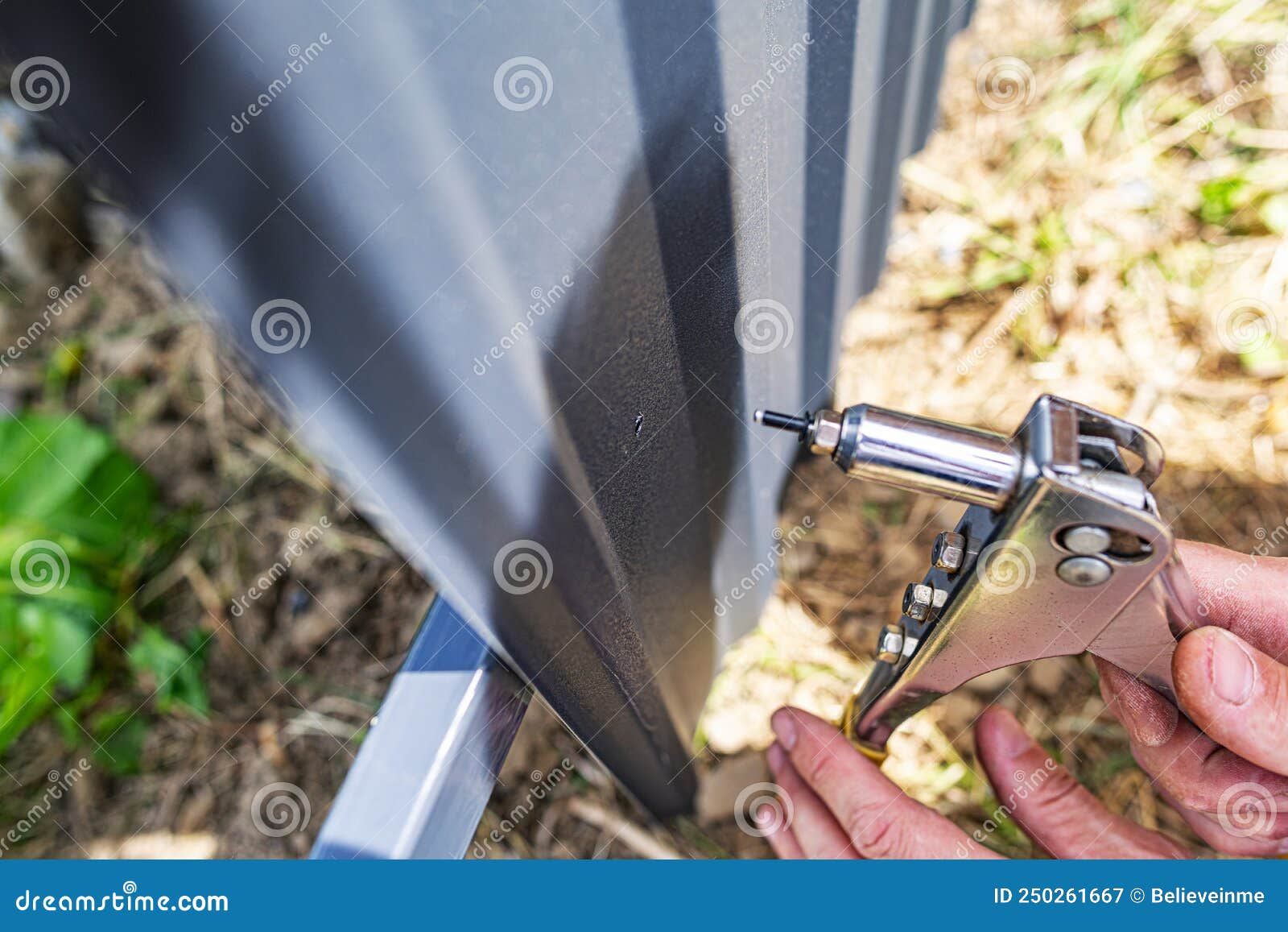 A Worker Puts Rivets into a Profiled Sheet on a Fence. Stock Image ...