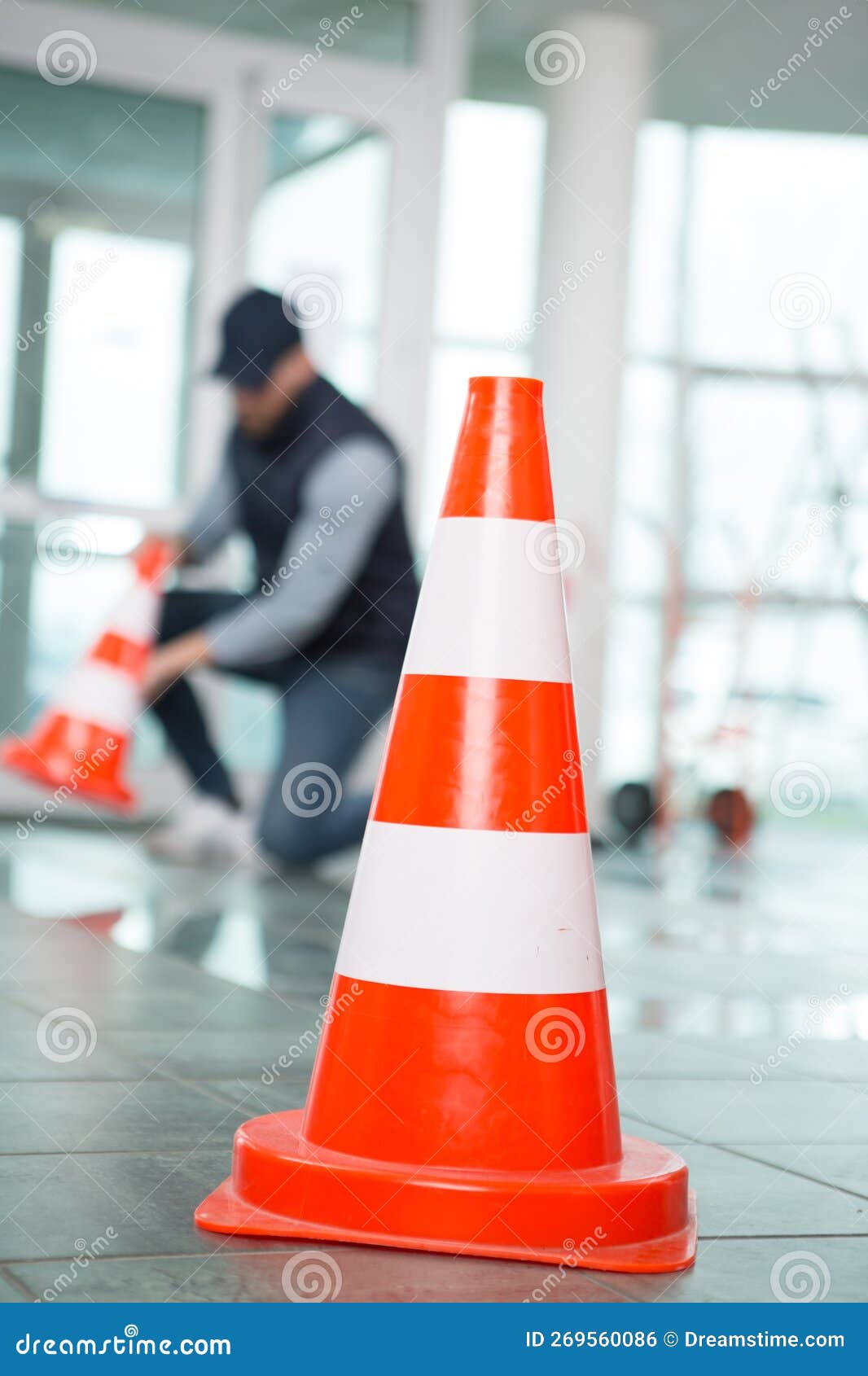 Worker Putting Cones Around Area Wetness on Tiled Floor Stock Photo ...