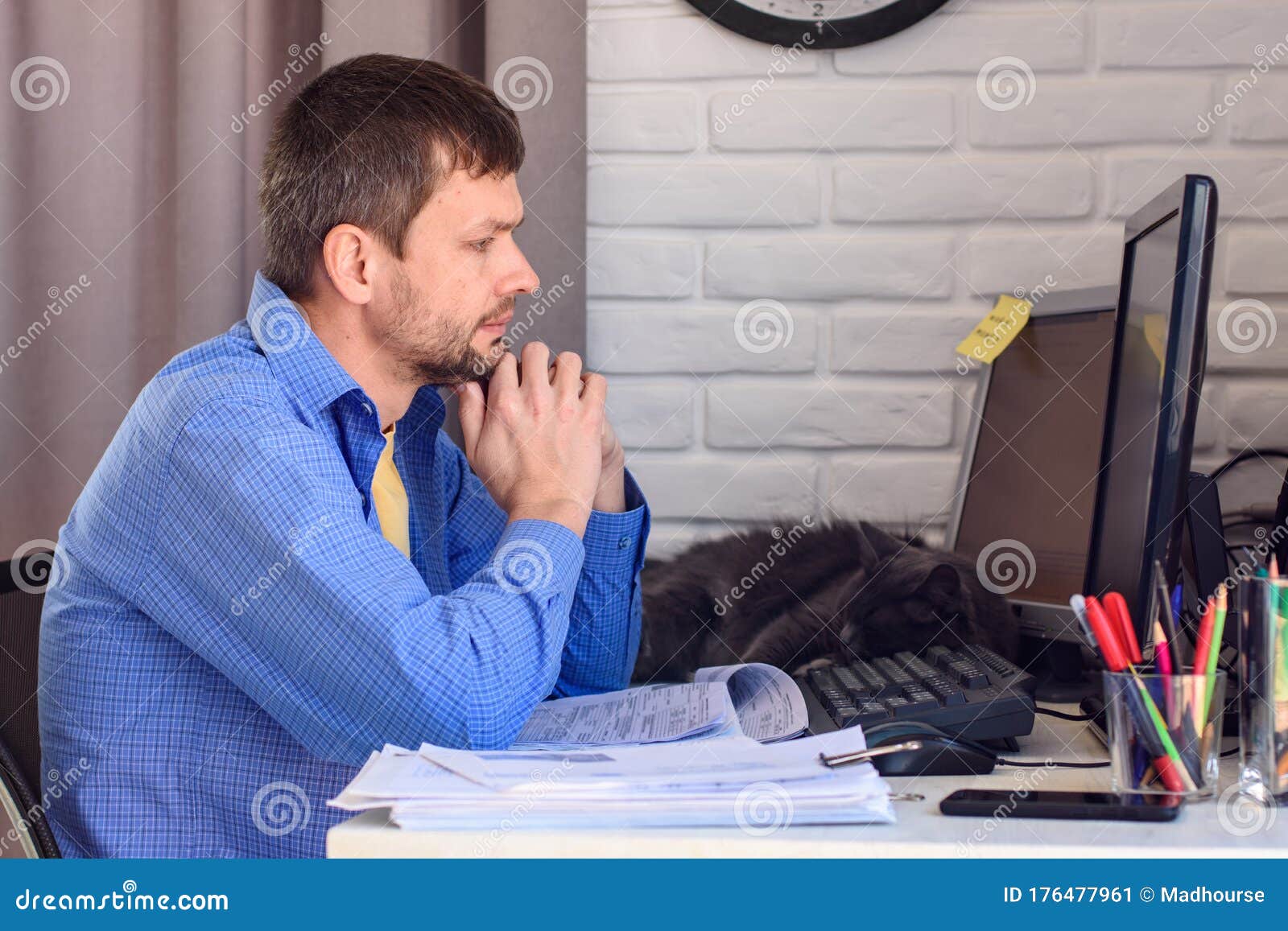 Worker at a Remote Work Looks Thoughtfully at a Monitor Screen Stock ...