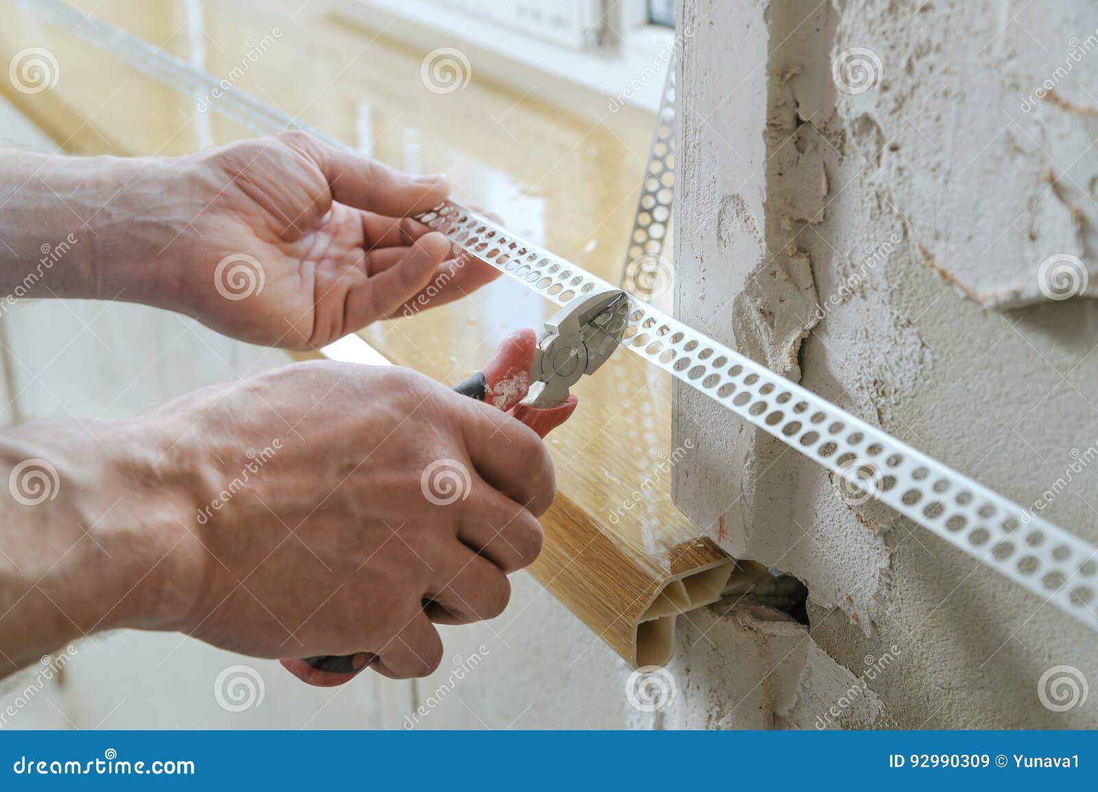 Worker`s Hands are Cutting a Perforated Aluminum Corner. Stock Image ...