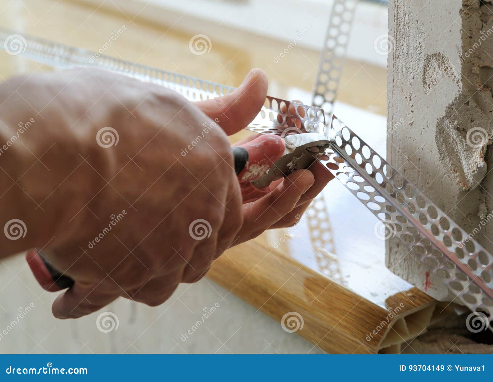 Worker`s Hands are Cutting a Perforated Aluminum Corner. Stock Image ...