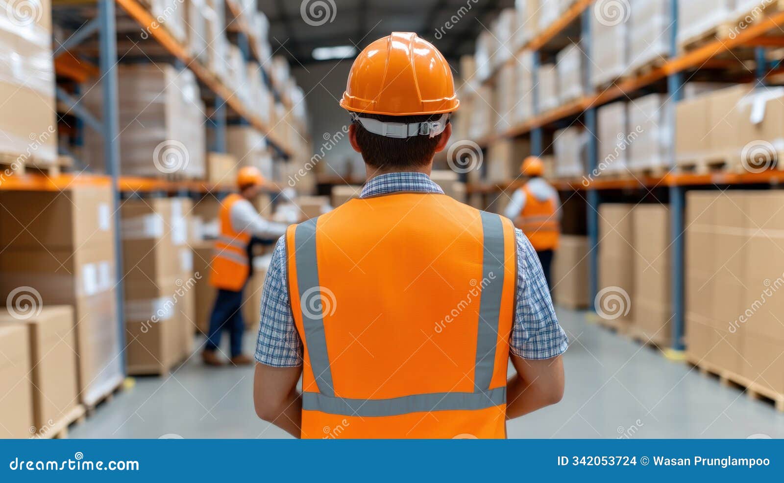 Worker in Safety Gear Overseeing Warehouse Operations and Inventory ...