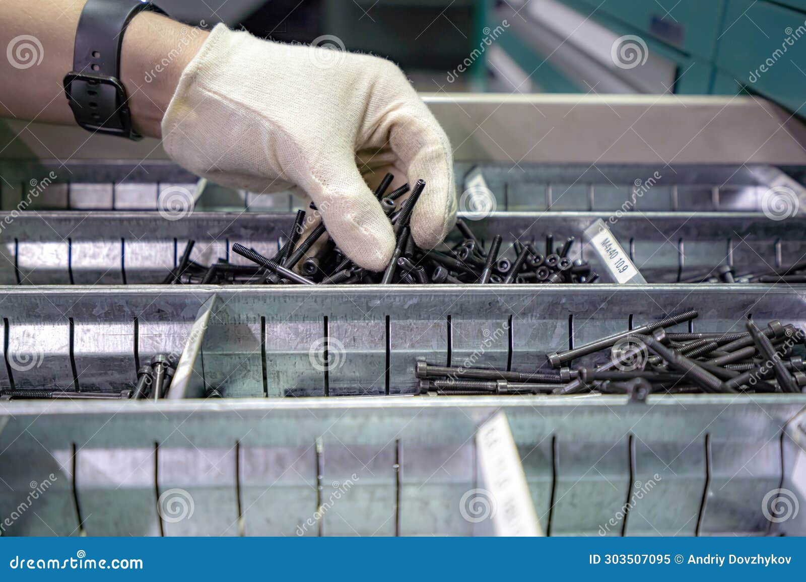 A Worker Selects Bolts and Nuts for Work from a Box of Hardware Stock ...