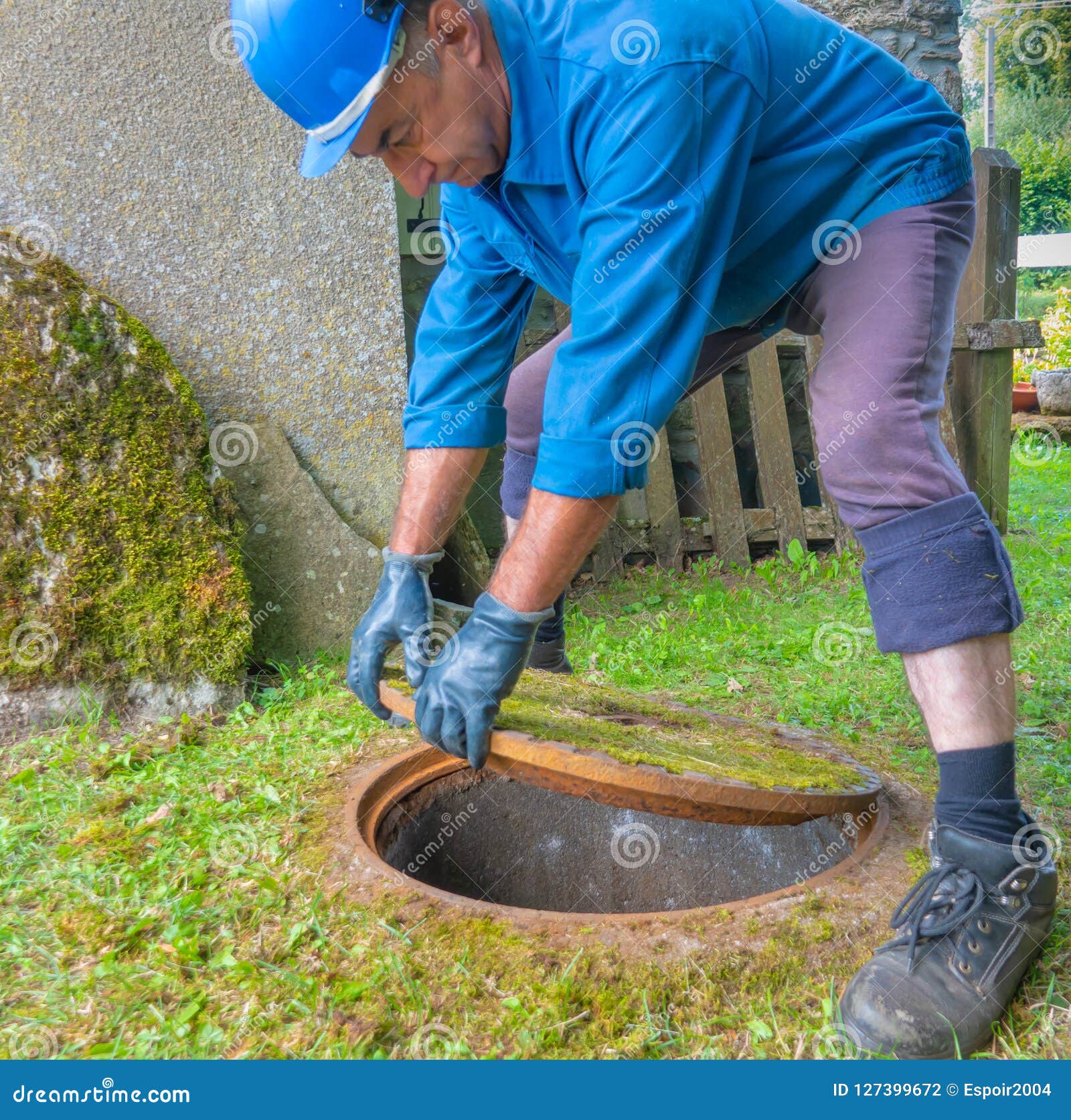 A Worker of Construction Opens a Manhole in To Descend Underground ...