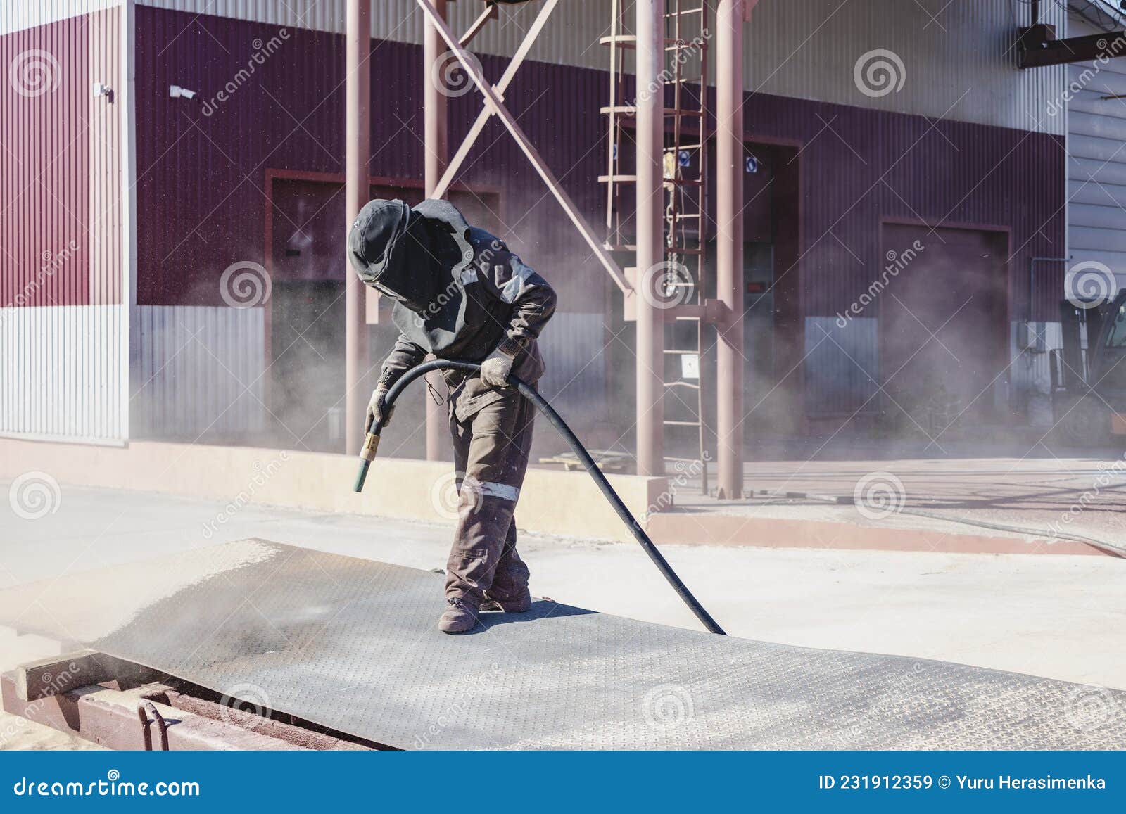 A Worker in a Special Suit is Sandblasting Metal at an Industrial Site ...