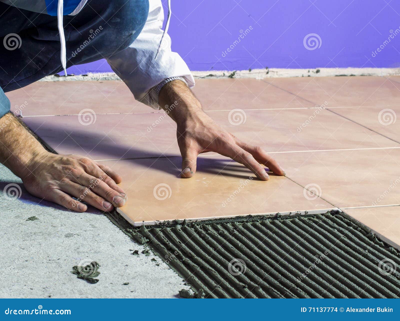 The Worker Spends Construction Work, Laying Tiles on the Floor Stock ...