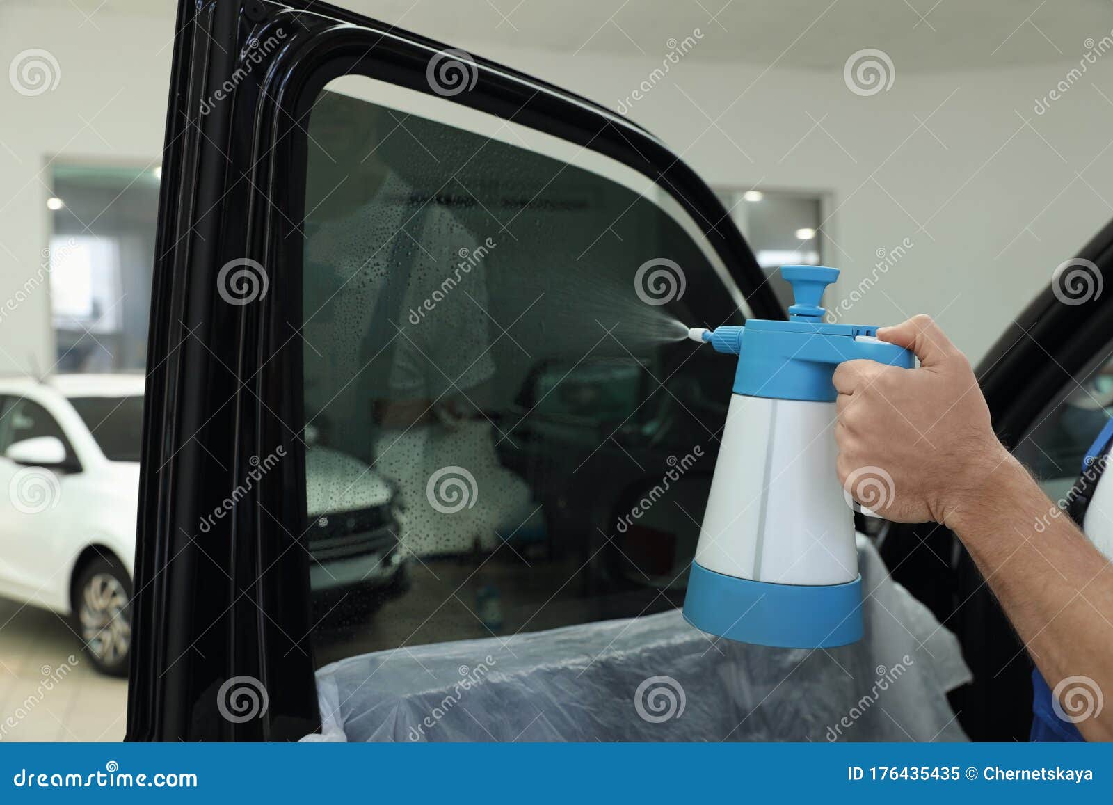 Worker Spraying Water Onto Tinted Car Window in Workshop Stock Image ...
