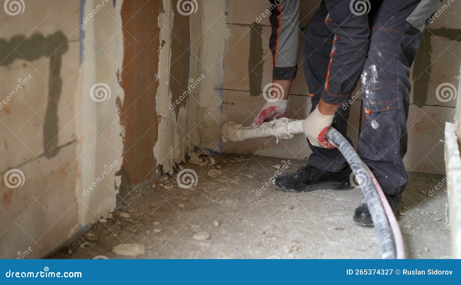 A Worker Sprays Putty on a Wall. the Process of Applying Plaster To ...