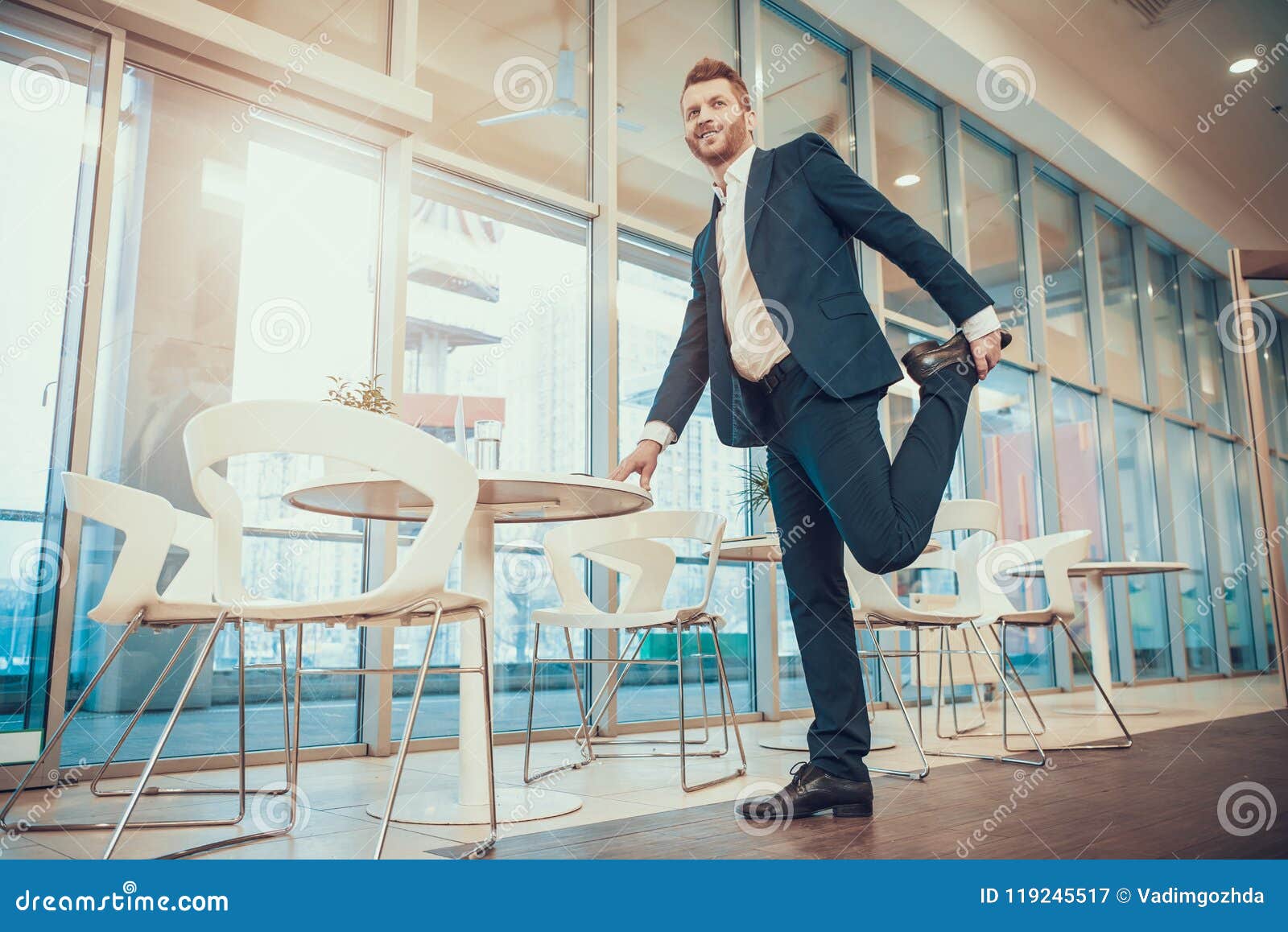 Worker Stretching Leg at Table in Office. Stock Image - Image of ...