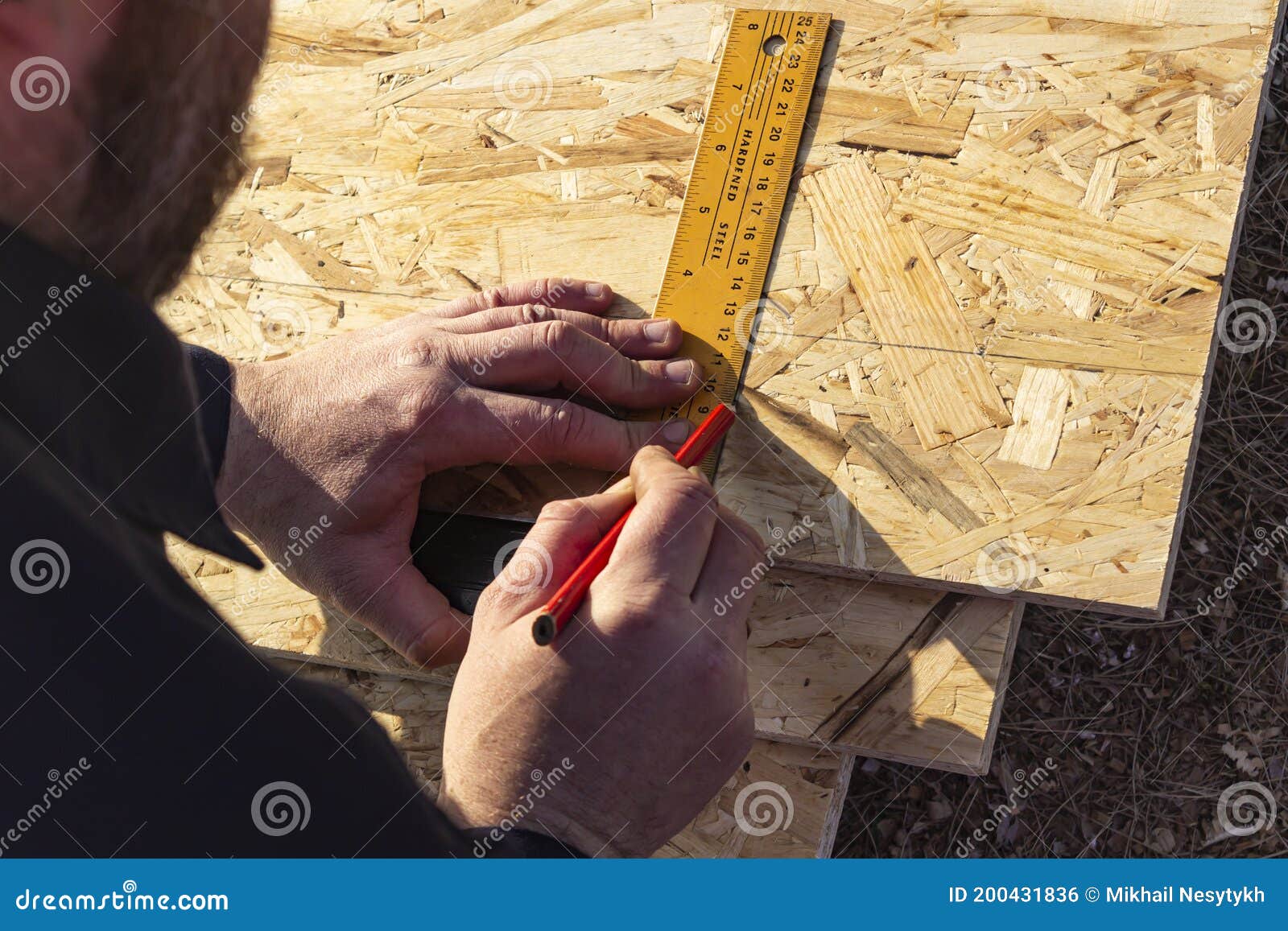 The Worker Takes Measurements and Marks on the OSB Sheet Using a Square ...