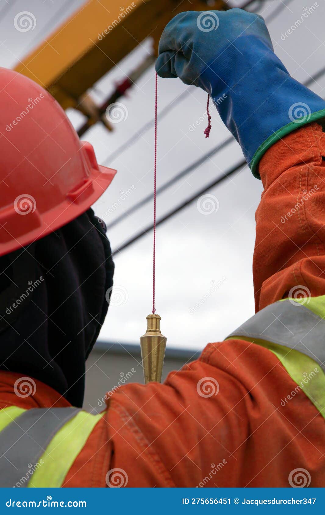 Worker Taking Measurement with a Pendulum Tool on Installation of a ...