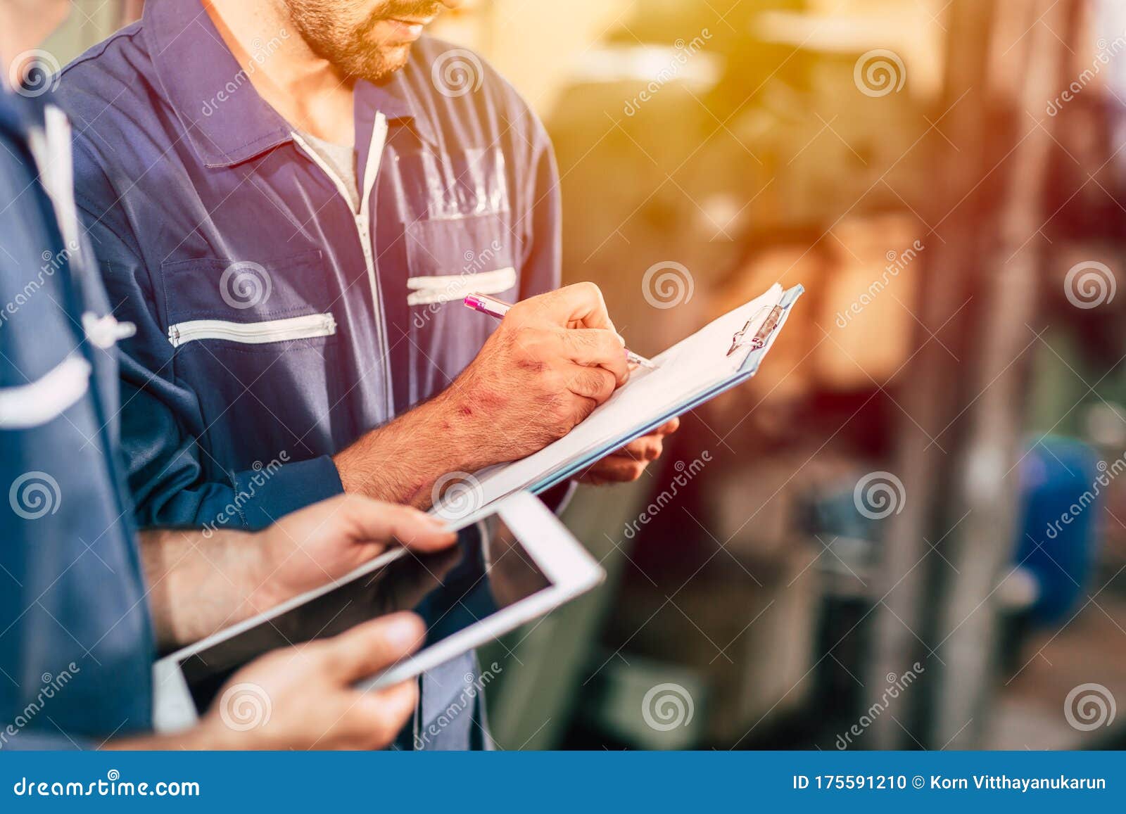 Worker Taking Note Using Pen and Paper with New Young Engineer Using ...