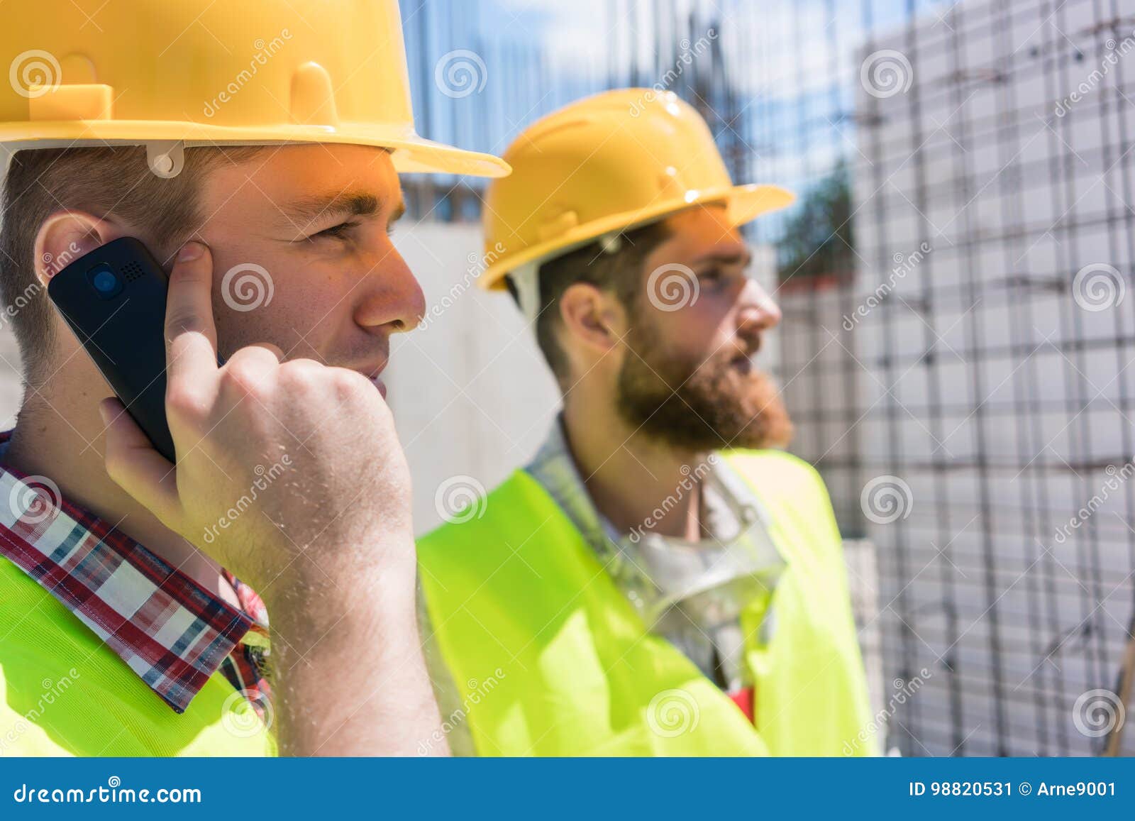 Worker Talking on Mobile Phone during Work on the Construction S Stock ...