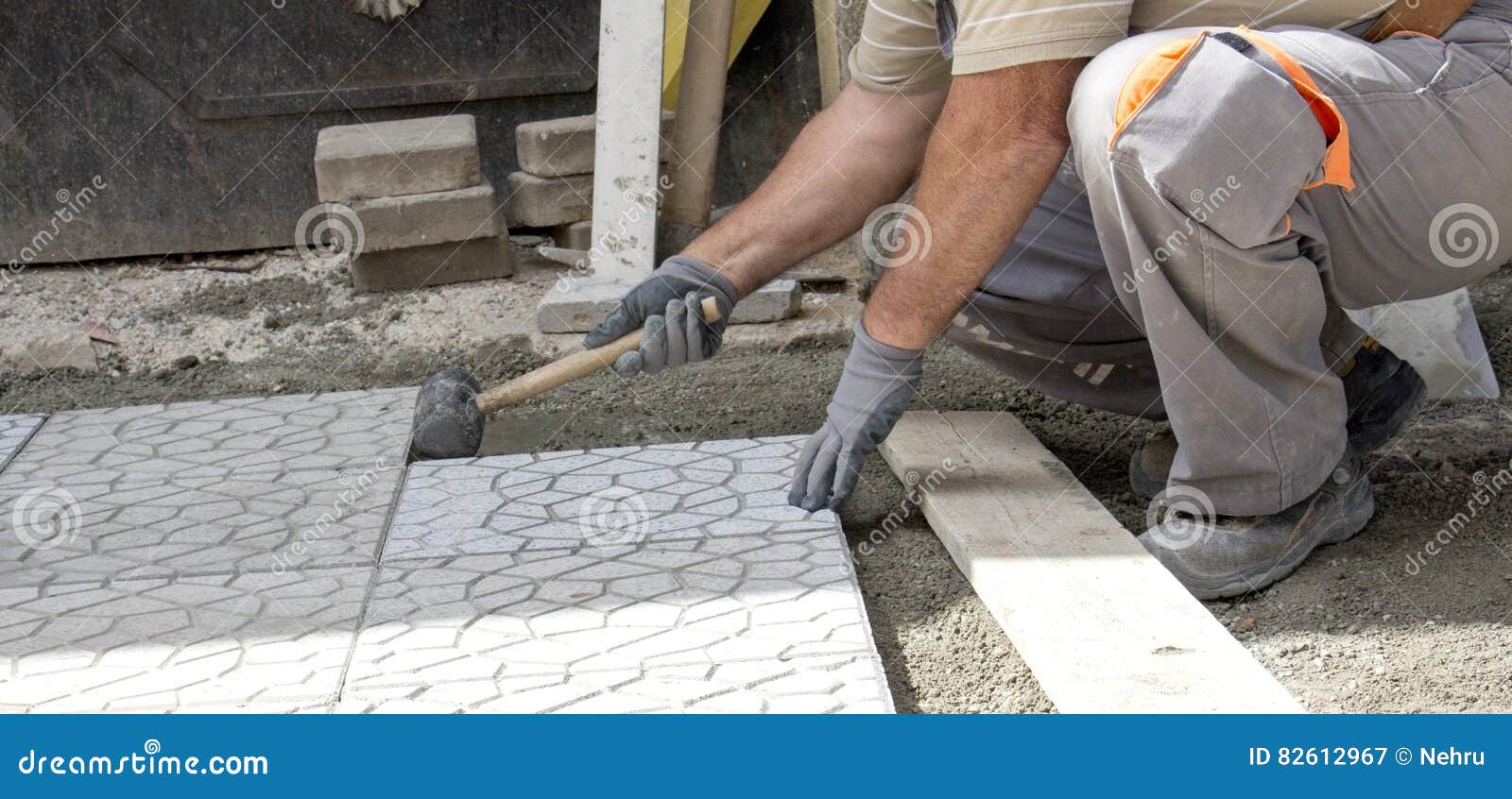 Worker Tapping Pavers into Place with Rubber Mallet. Stock Image ...