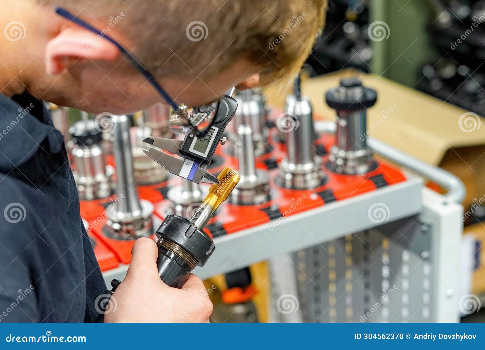 A Worker in a Tool Warehouse Inspects and Selects Cutters for Work on a ...