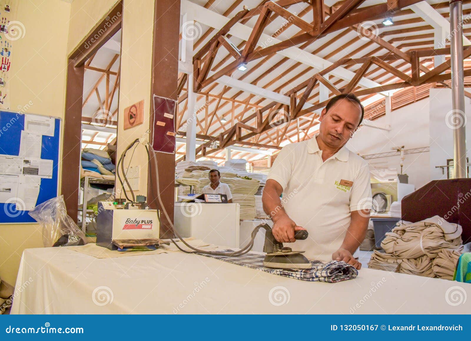 Worker in Uniform Ironing Clothes in the Laundry Editorial Photography ...