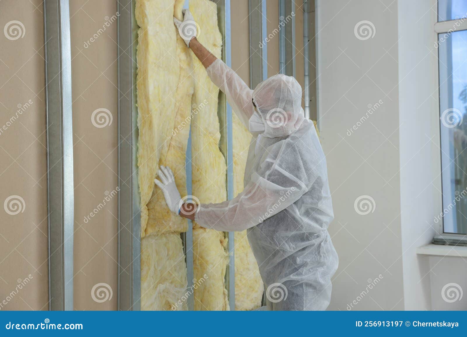 Worker in Uniform and Respiratory Mask Insulating Wall Indoors Stock ...