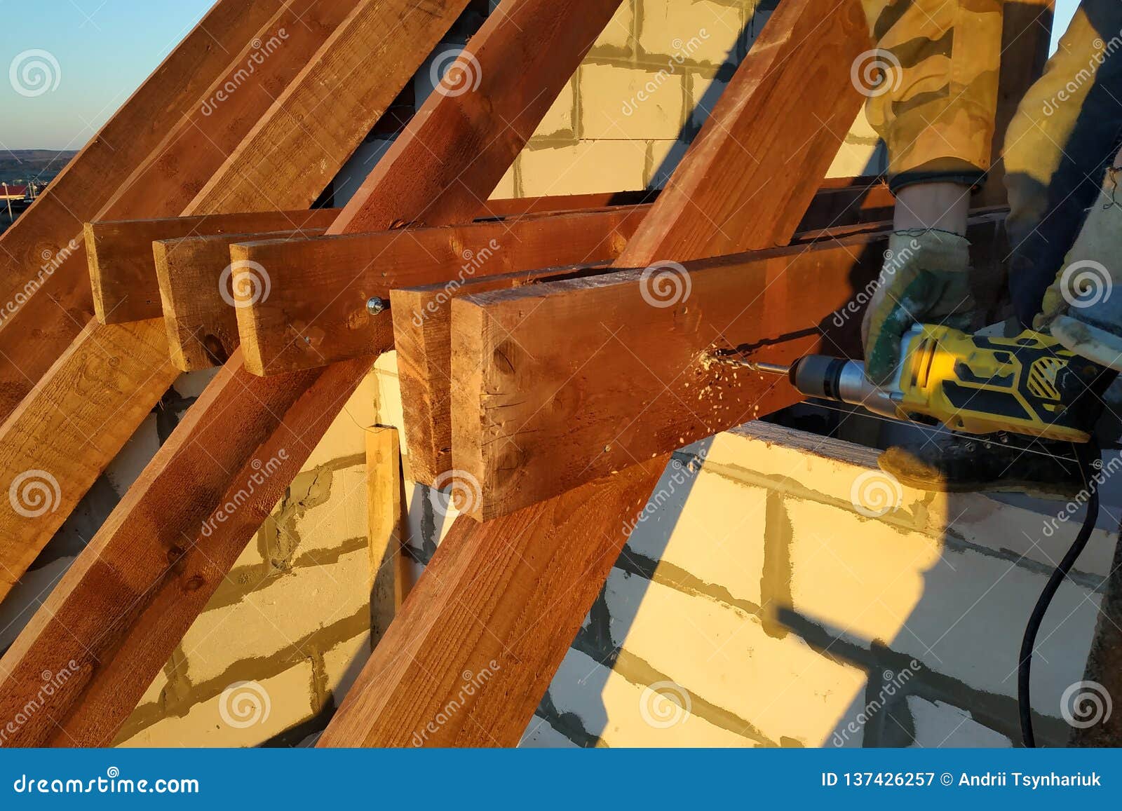 The Worker Uses a Drill in the Construction of the Roof Stock Image ...
