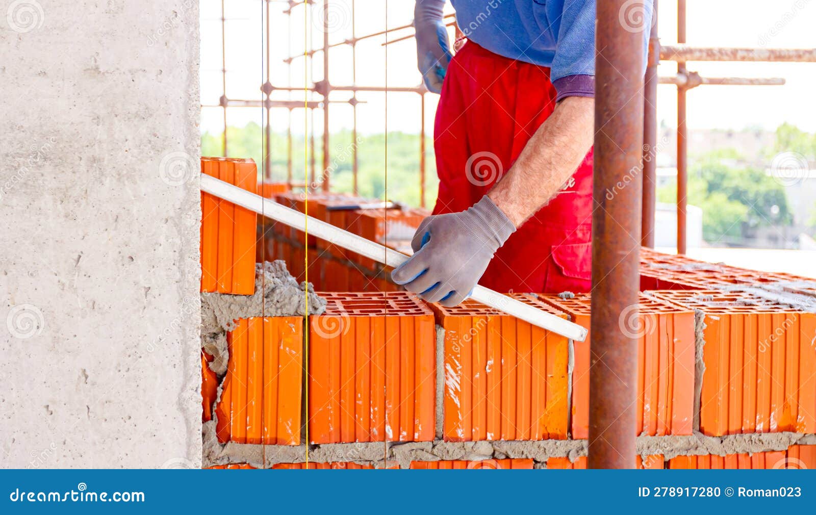 Worker Uses a Spirit Level To Control Wall Made of Red Blocks Stock ...